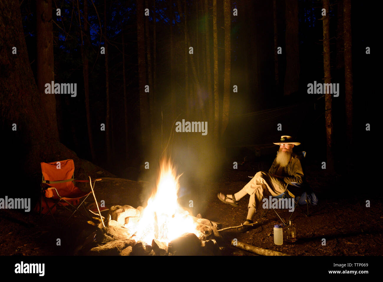 Man sitting in front campfire hi-res stock photography and images - Alamy