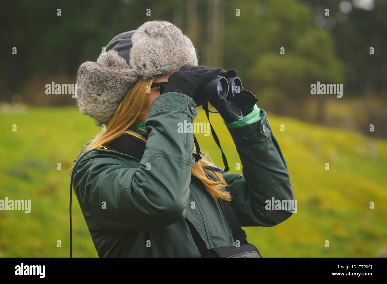 Side view of woman looking through binoculars Stock Photo - Alamy