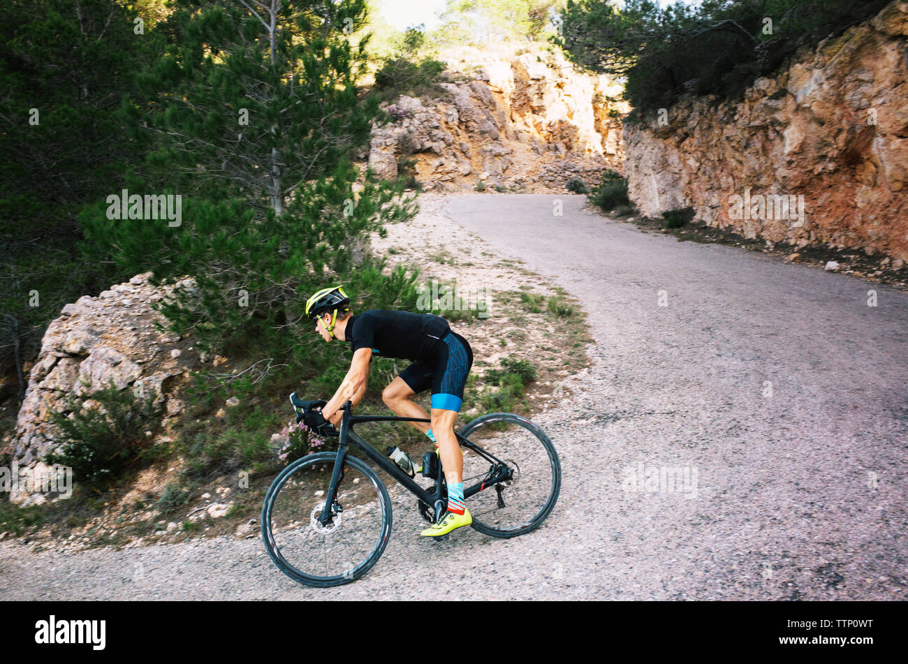 Side view of man cycling on street Stock Photo - Alamy