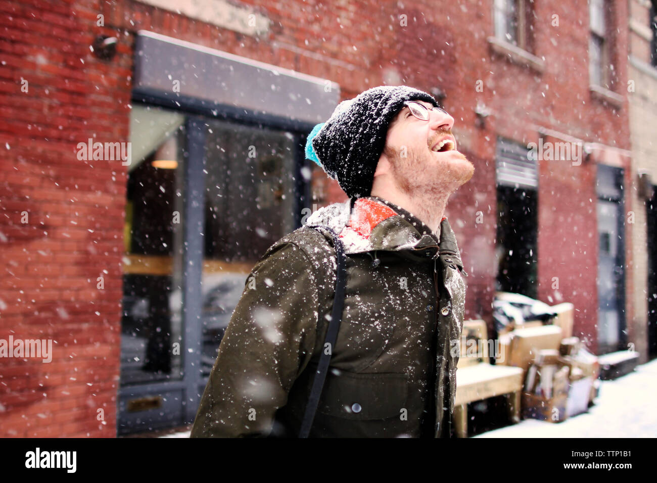 Happy man enjoying snow in city Stock Photo - Alamy