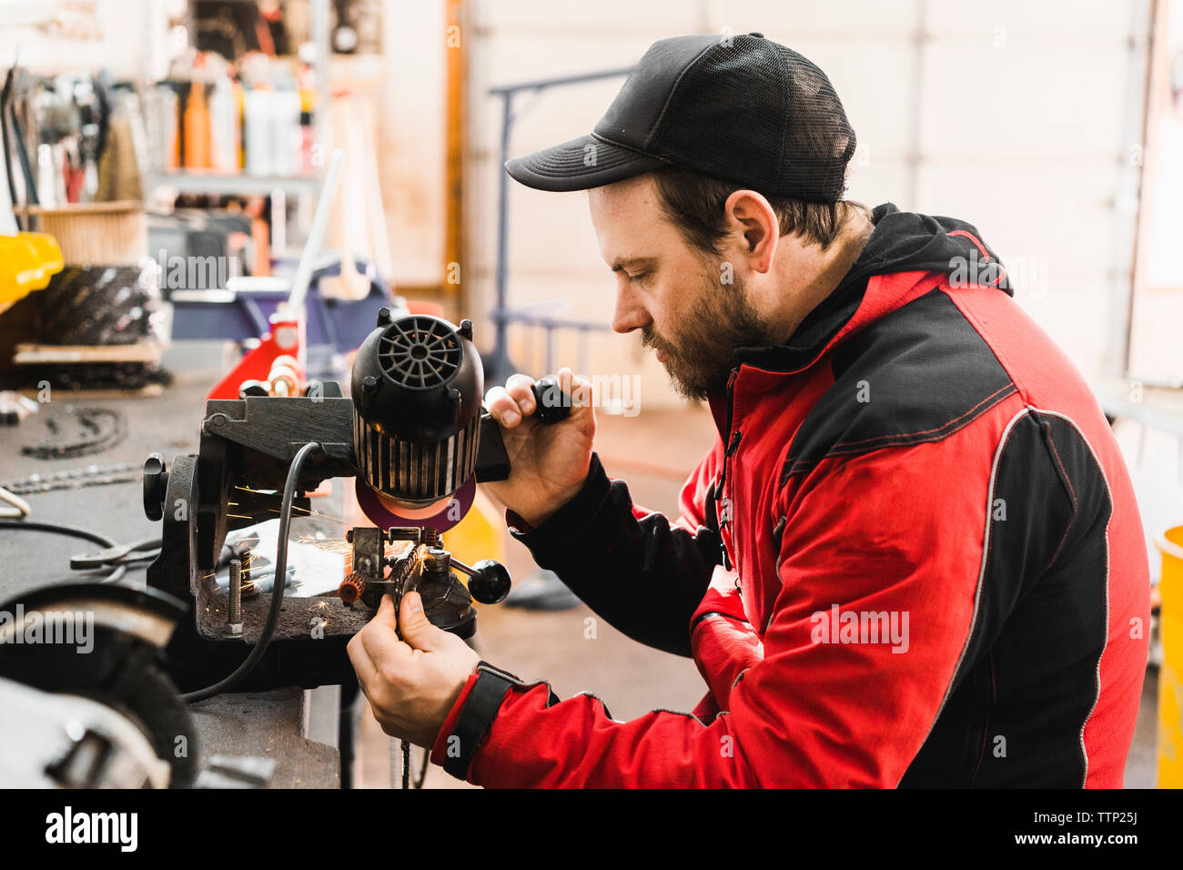 Side view of man welding chain in workshop Stock Photo - Alamy