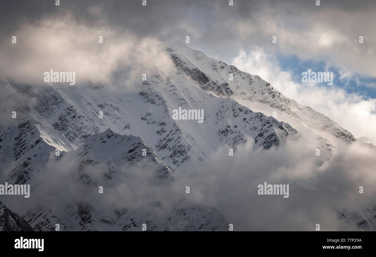 Scenic view of snowcapped mountain against cloudy sky Stock Photo - Alamy