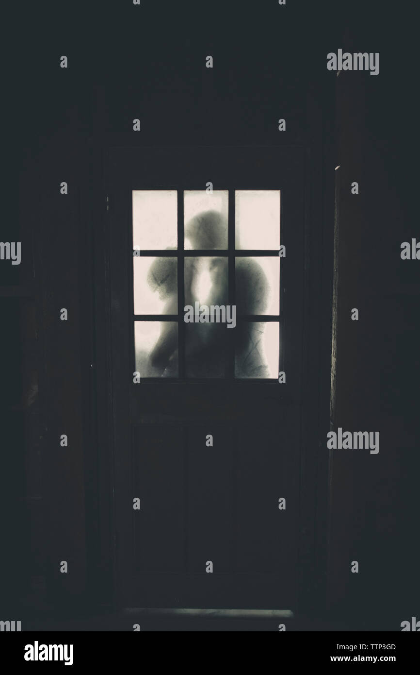 Newlywed couple kissing seen through cottage window Stock Photo - Alamy