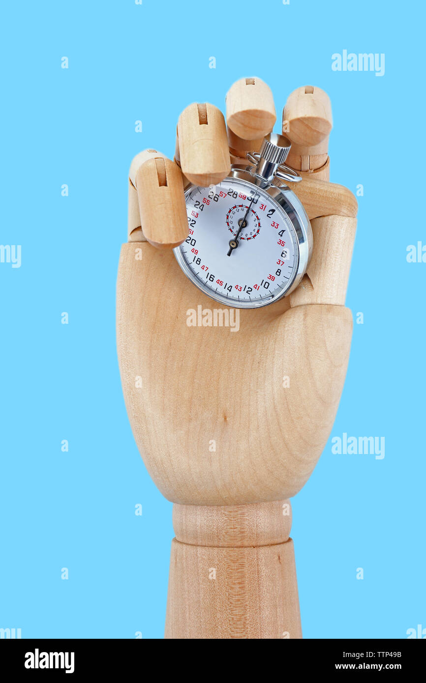 Wooden hand holding stopwatch on white background Stock Photo - Alamy