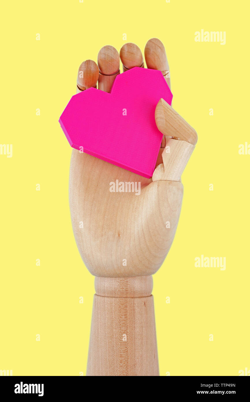 Wooden hand holding pink heart on white background Stock Photo - Alamy