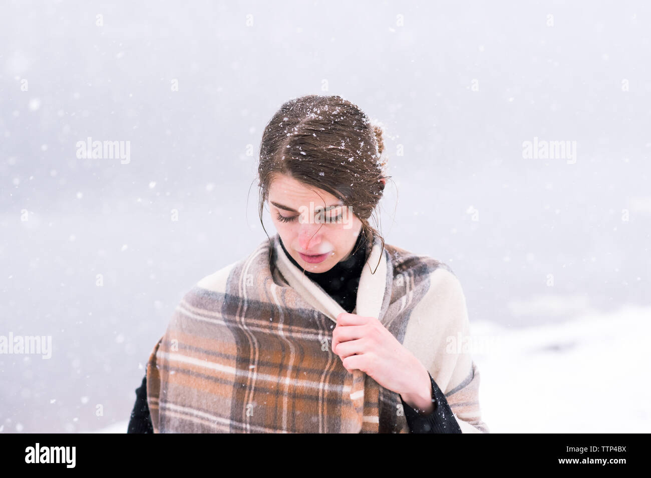 Woman wrapped in scarf outside during snowfall Stock Photo - Alamy