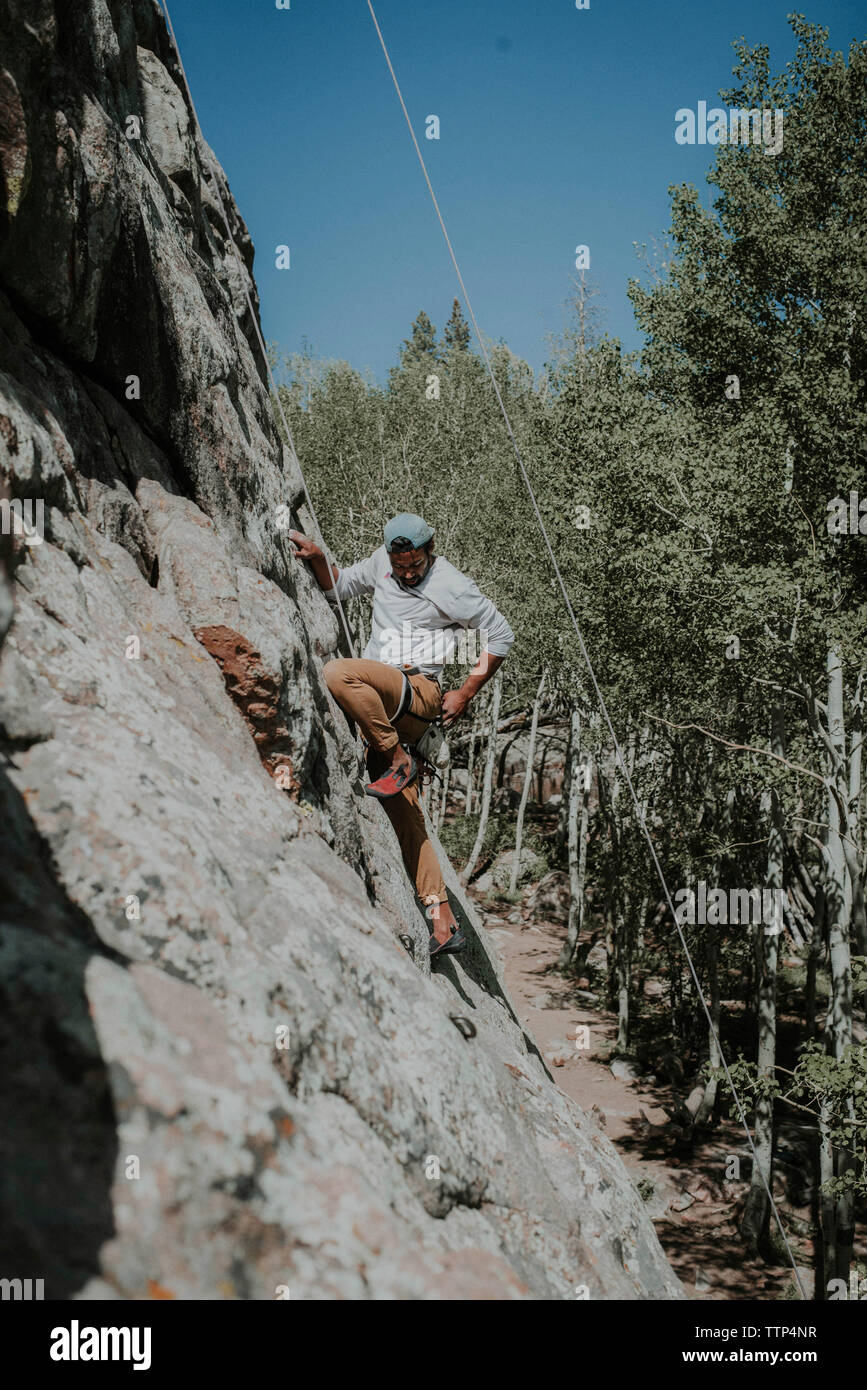 Man looking down while mountain climbing Stock Photo - Alamy