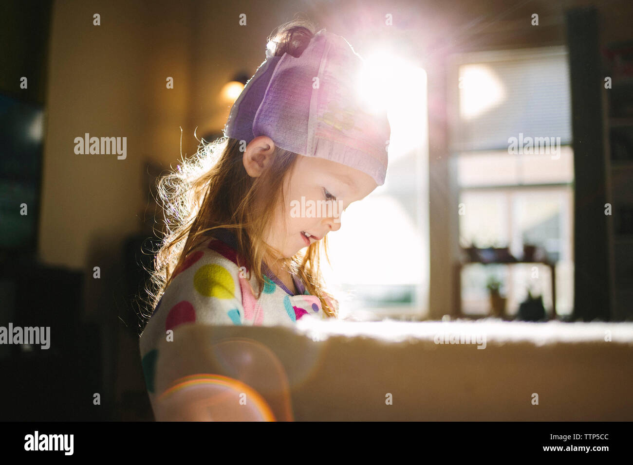 Side view of girl wearing hat at home Stock Photo - Alamy