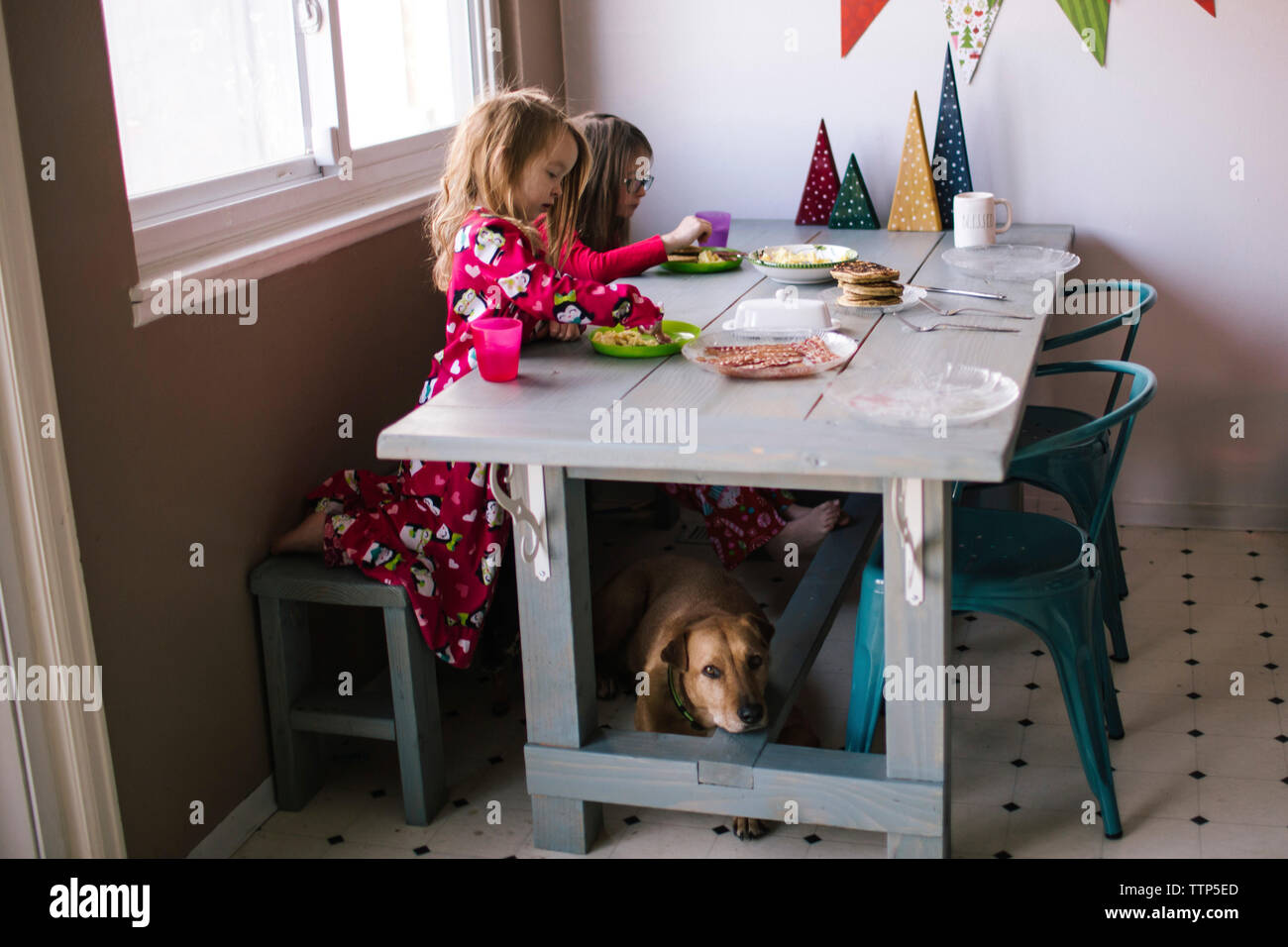 Sisters eating food at table Stock Photo - Alamy