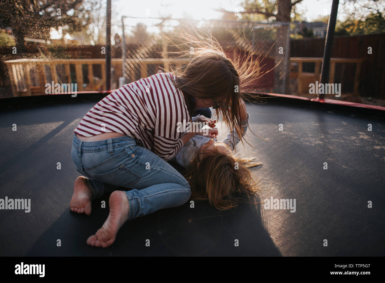 High angle view of sisters playing on trampoline Stock Photo - Alamy