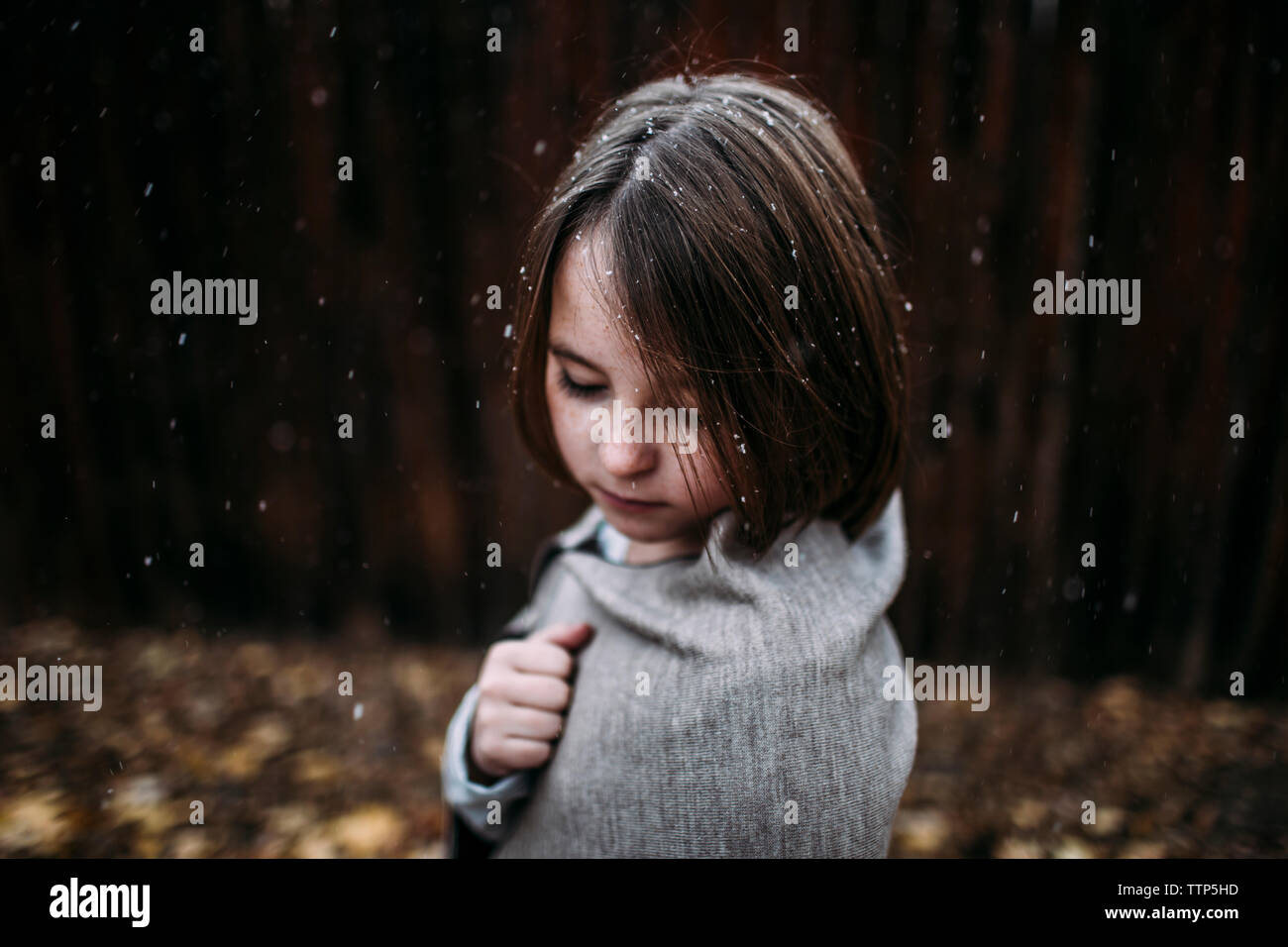 Side view of girl standing at backyard during snowfall Stock Photo - Alamy