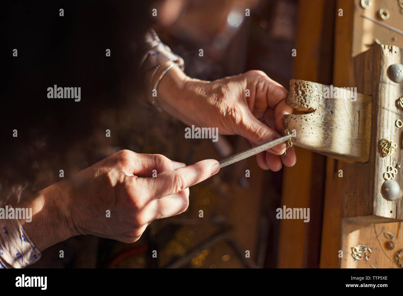 Overhead view of female goldsmith making jewelry in workshop Stock ...