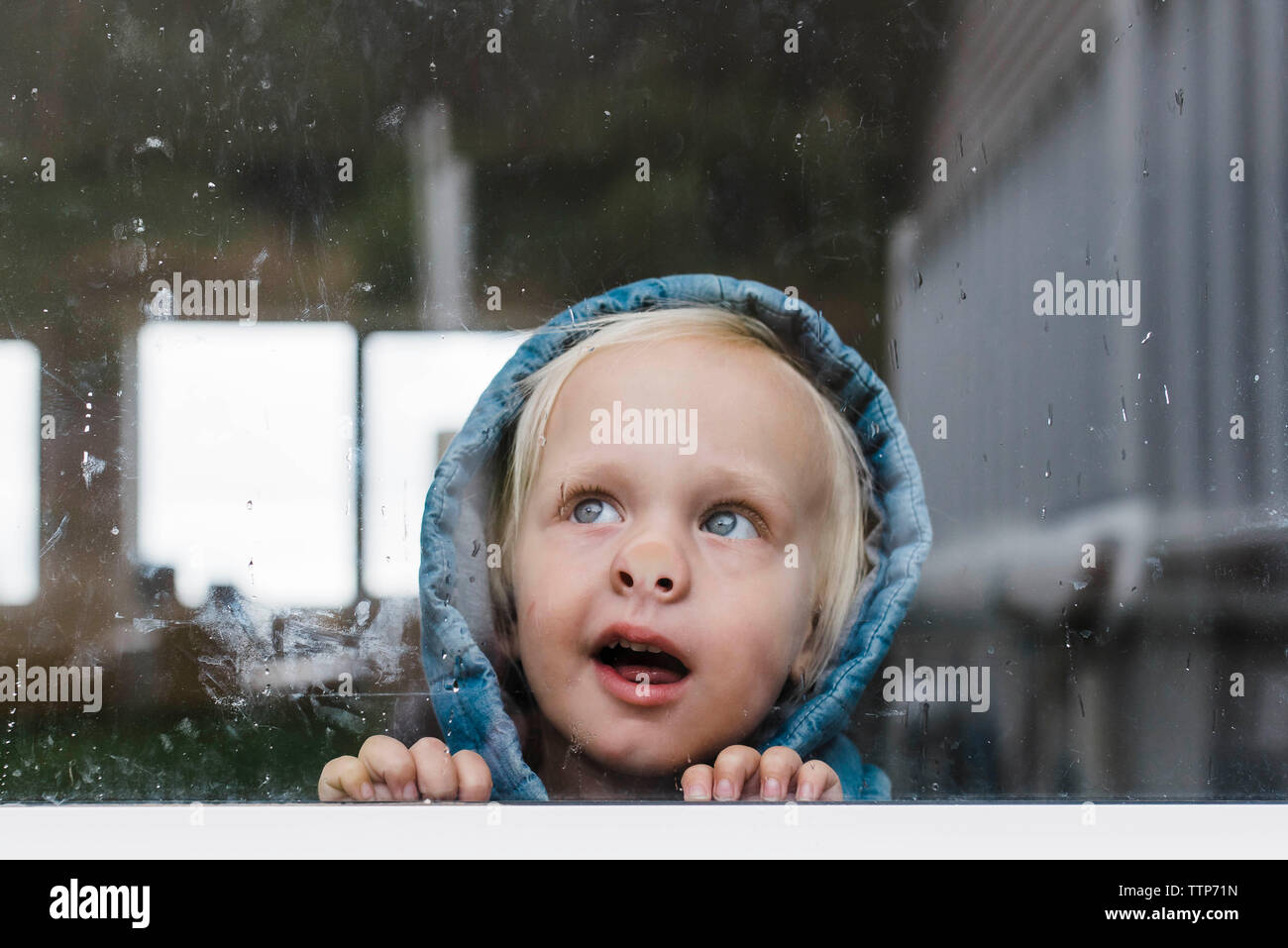 Close-up of girl looking through window seen through glass Stock Photo ...