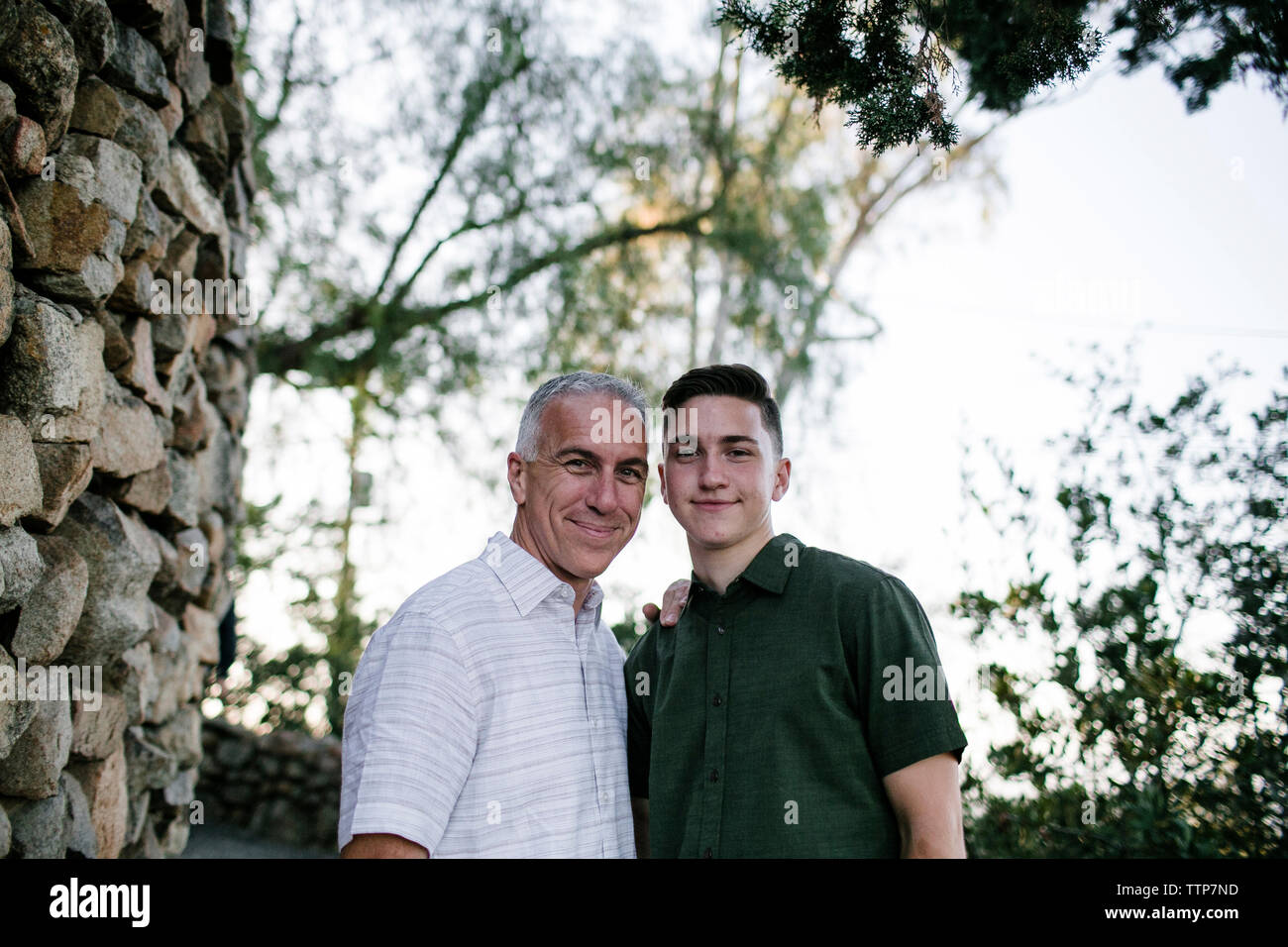 Low angle portrait of father with son standing against sky at park ...