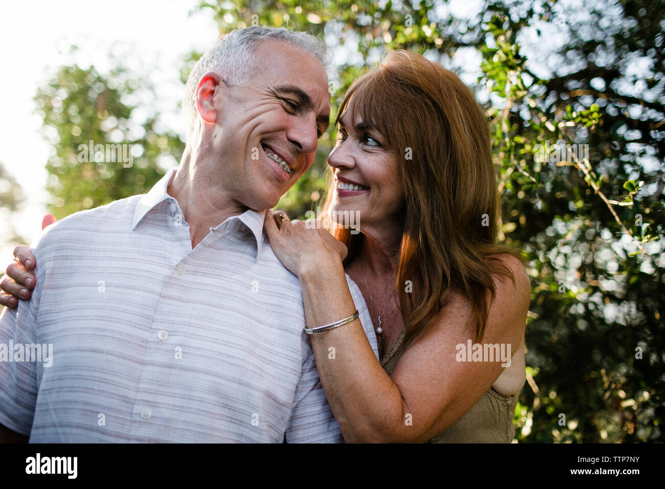 Low angle view of romantic couple smiling while looking at each other ...