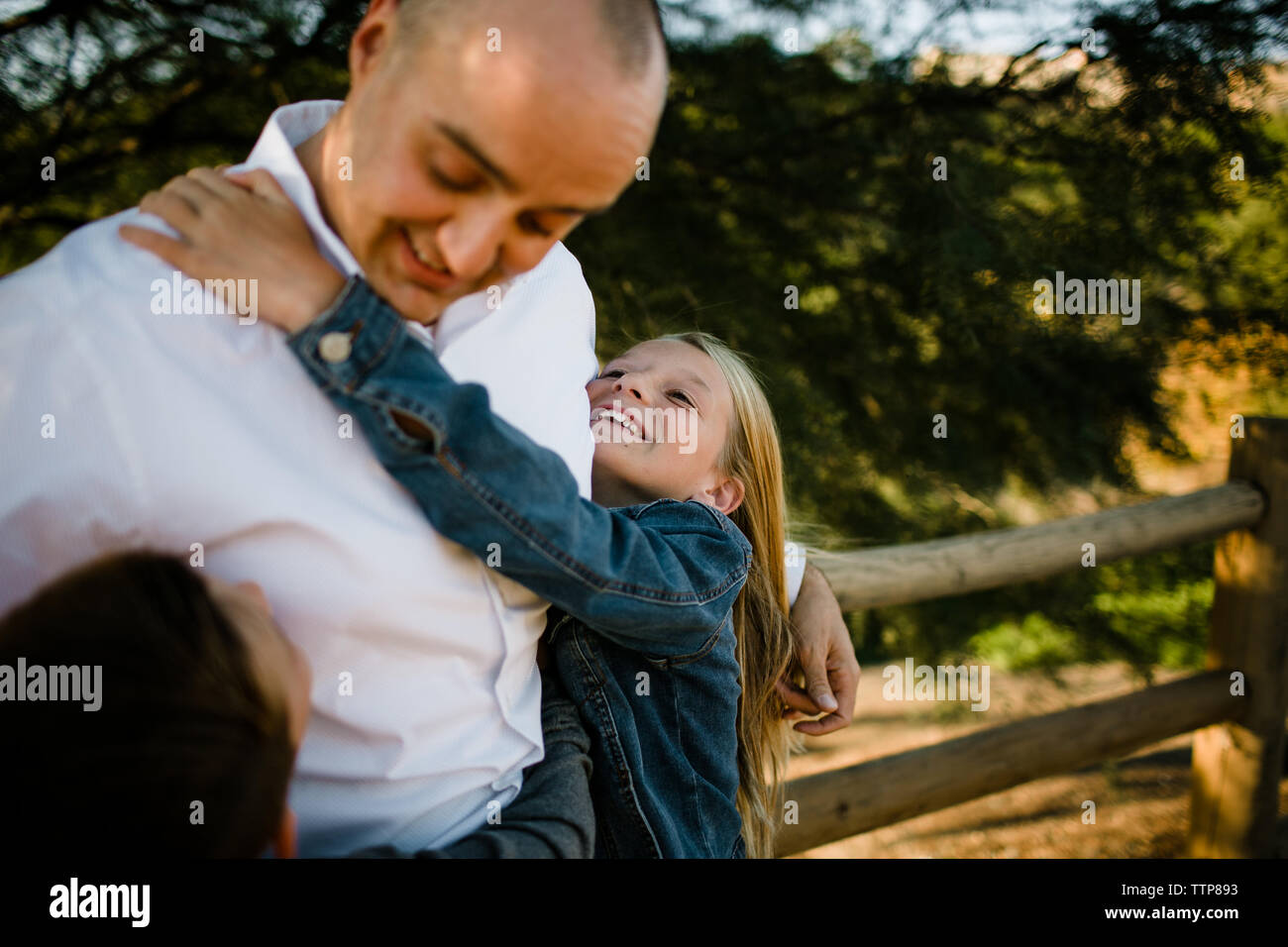 Daughter Grabbing Dad for Hugs While Smiling in SoCal Stock Photo - Alamy