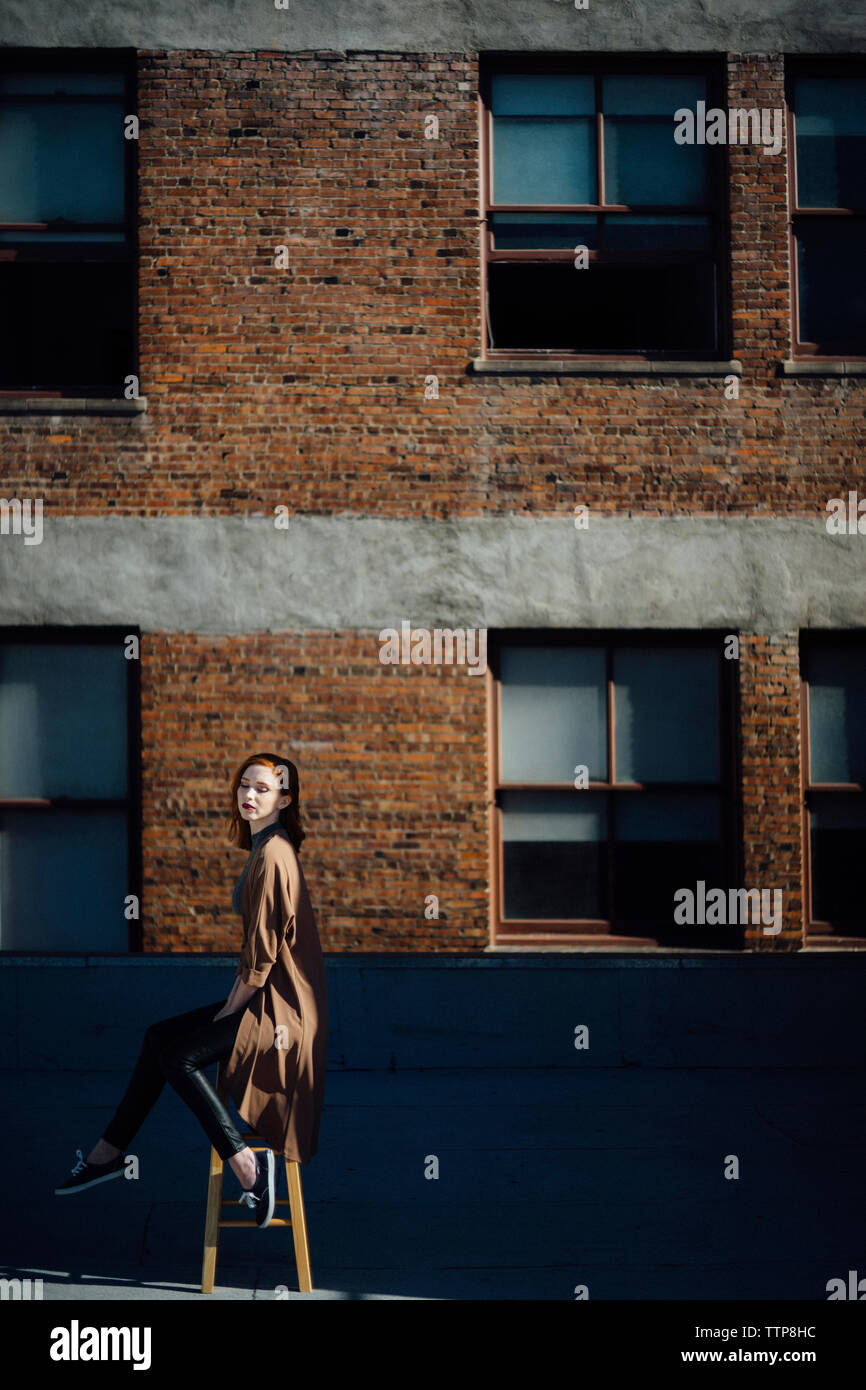 Woman sitting on stool hi-res stock photography and images - Alamy