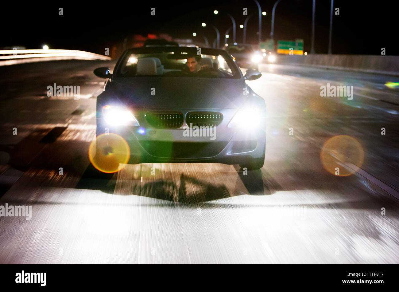 Man driving car on illuminated street at night Stock Photo - Alamy