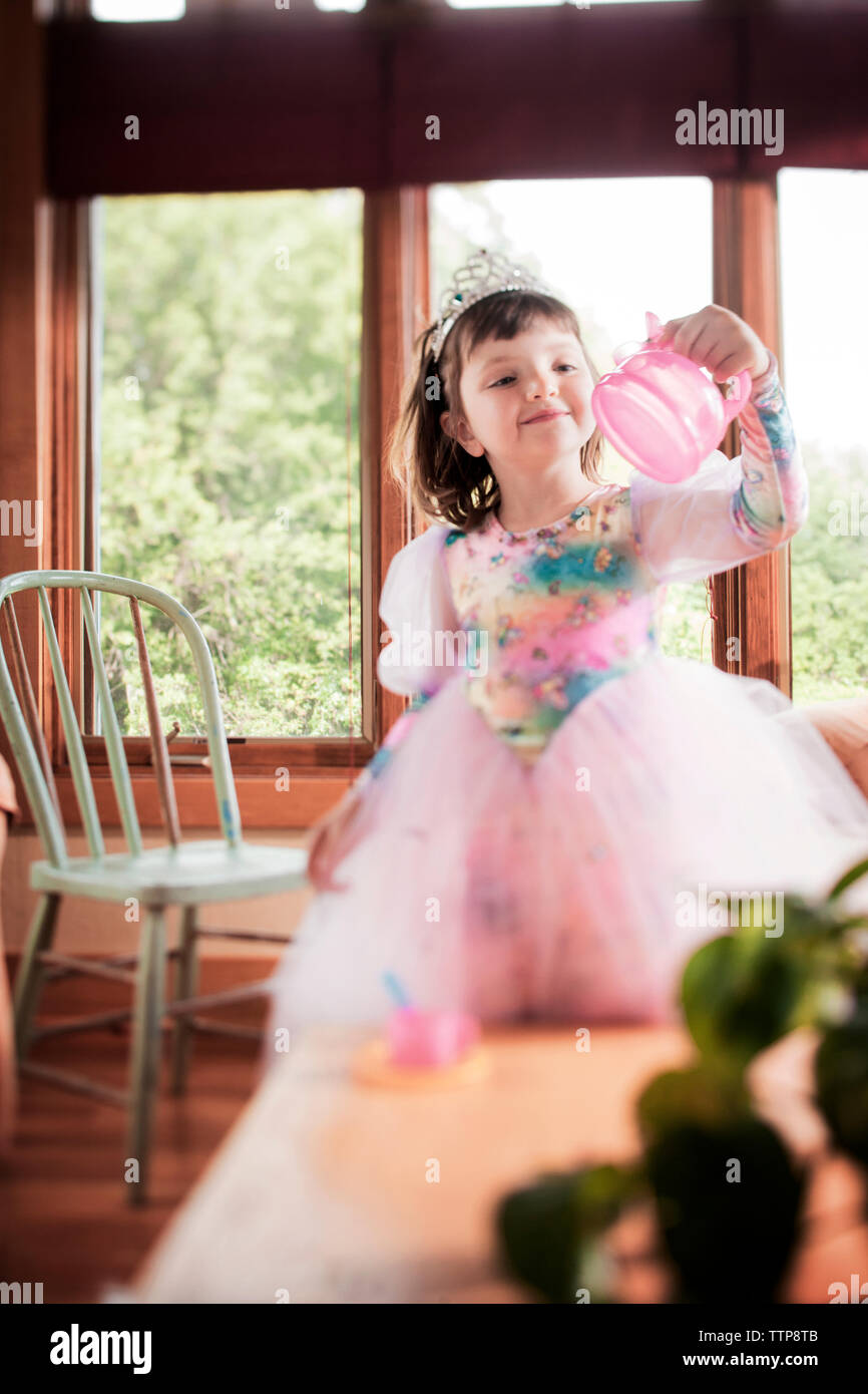 Smiling girl wearing princess costume standing at home Stock Photo - Alamy
