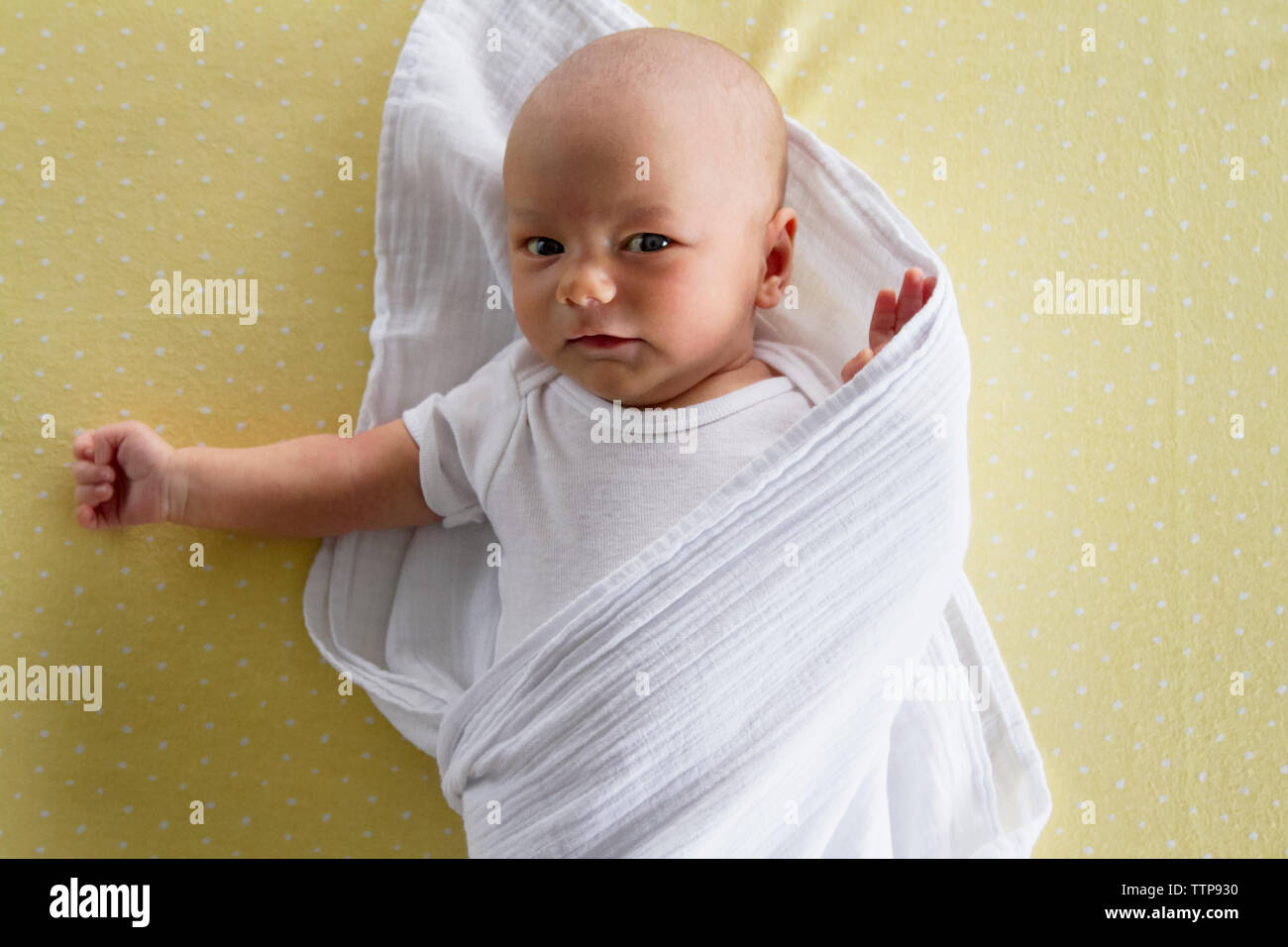 Overhead view of baby girl lying on bed Stock Photo - Alamy