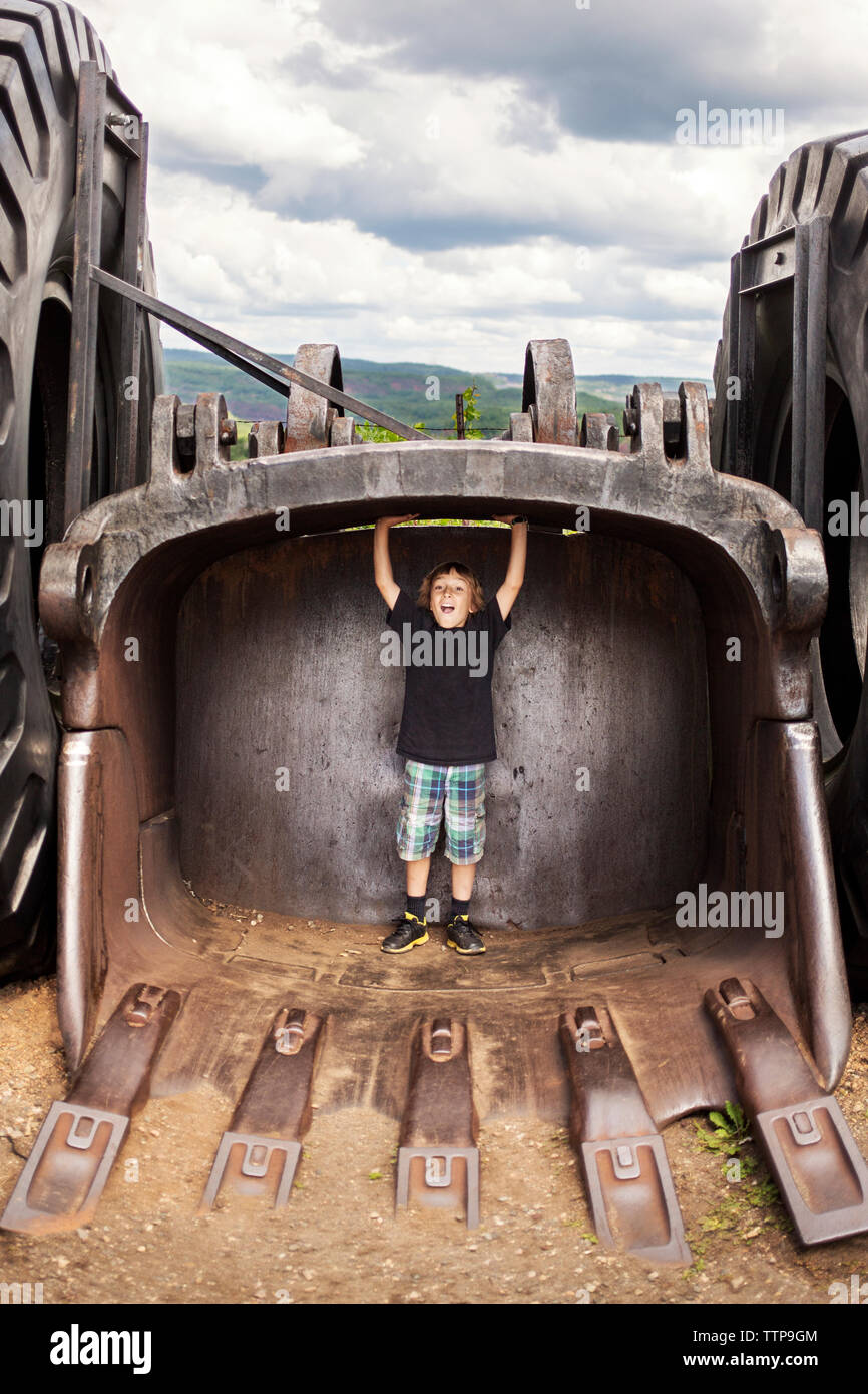 Happy boy standing in metal container at field Stock Photo - Alamy