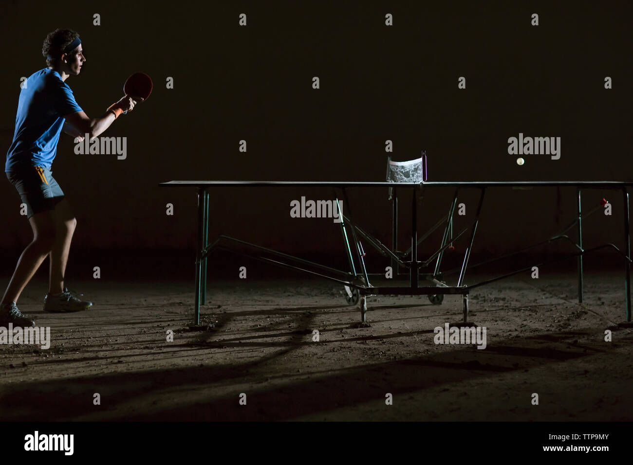 Man playing table tennis against building Stock Photo - Alamy