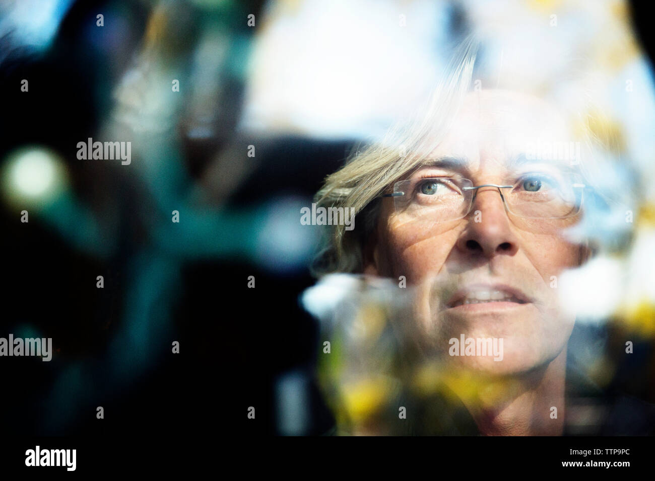 Close-up of thoughtful senior man seen through glass window Stock Photo ...