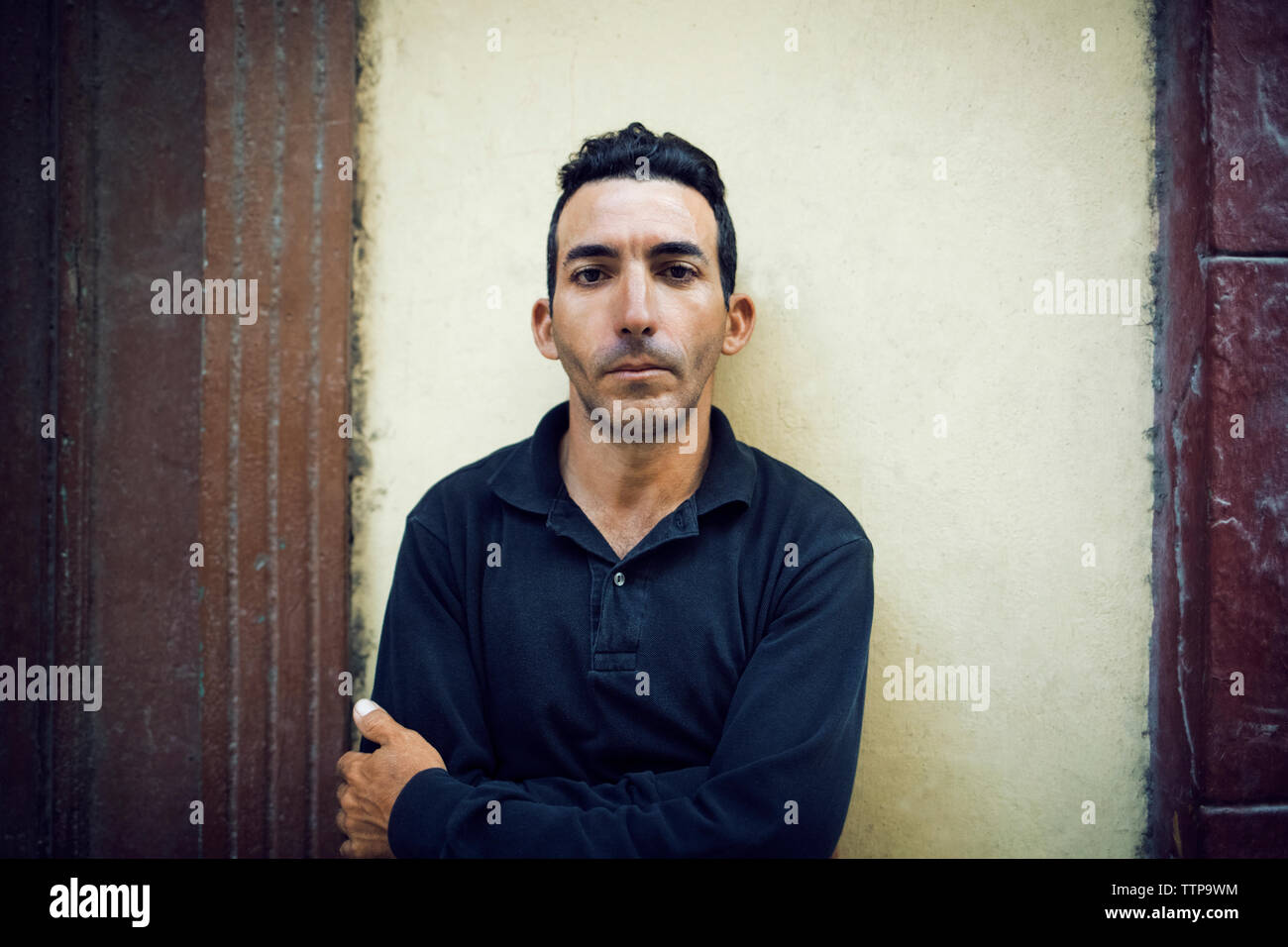 Portrait of man standing against wall Stock Photo - Alamy