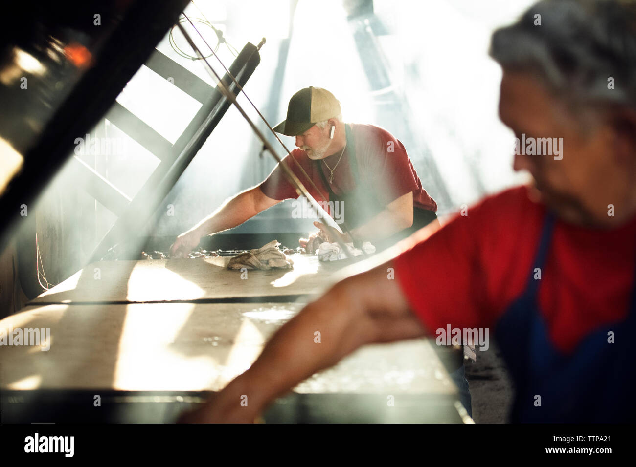 Workers cooking food in restaurant Stock Photo - Alamy