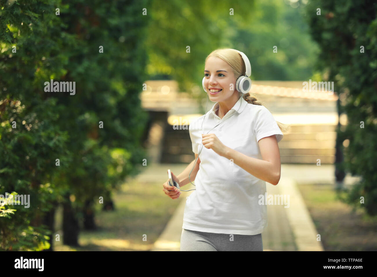 Beautiful girl running in spring park Stock Photo - Alamy