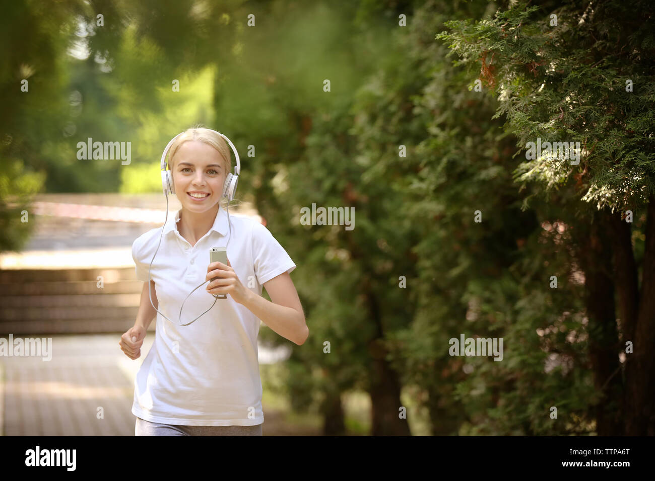 Beautiful girl running in spring park Stock Photo - Alamy