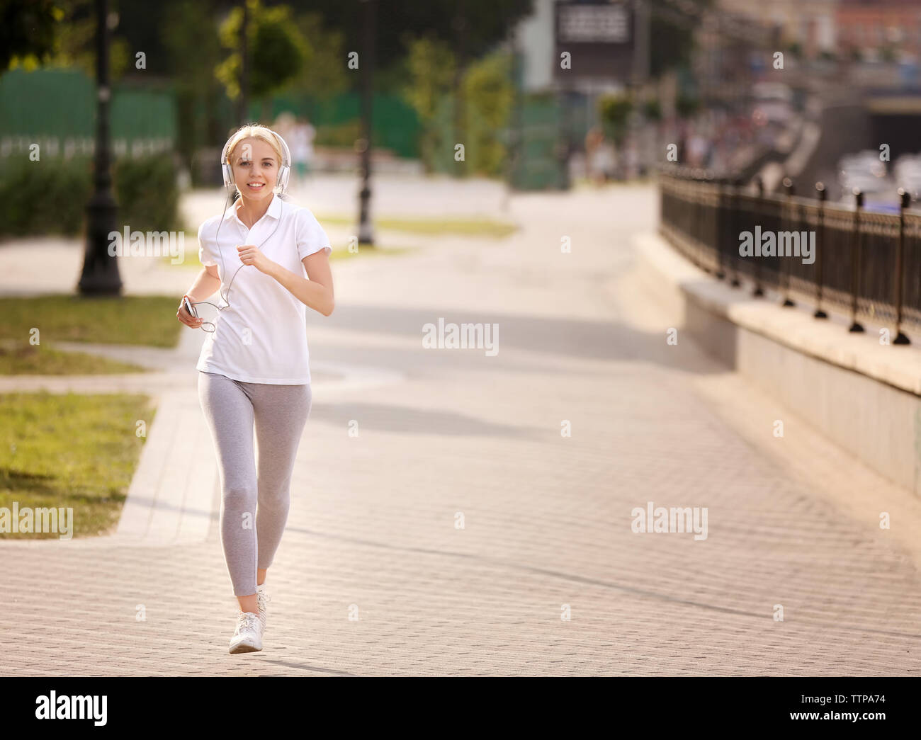 Beautiful girl running in spring park Stock Photo - Alamy