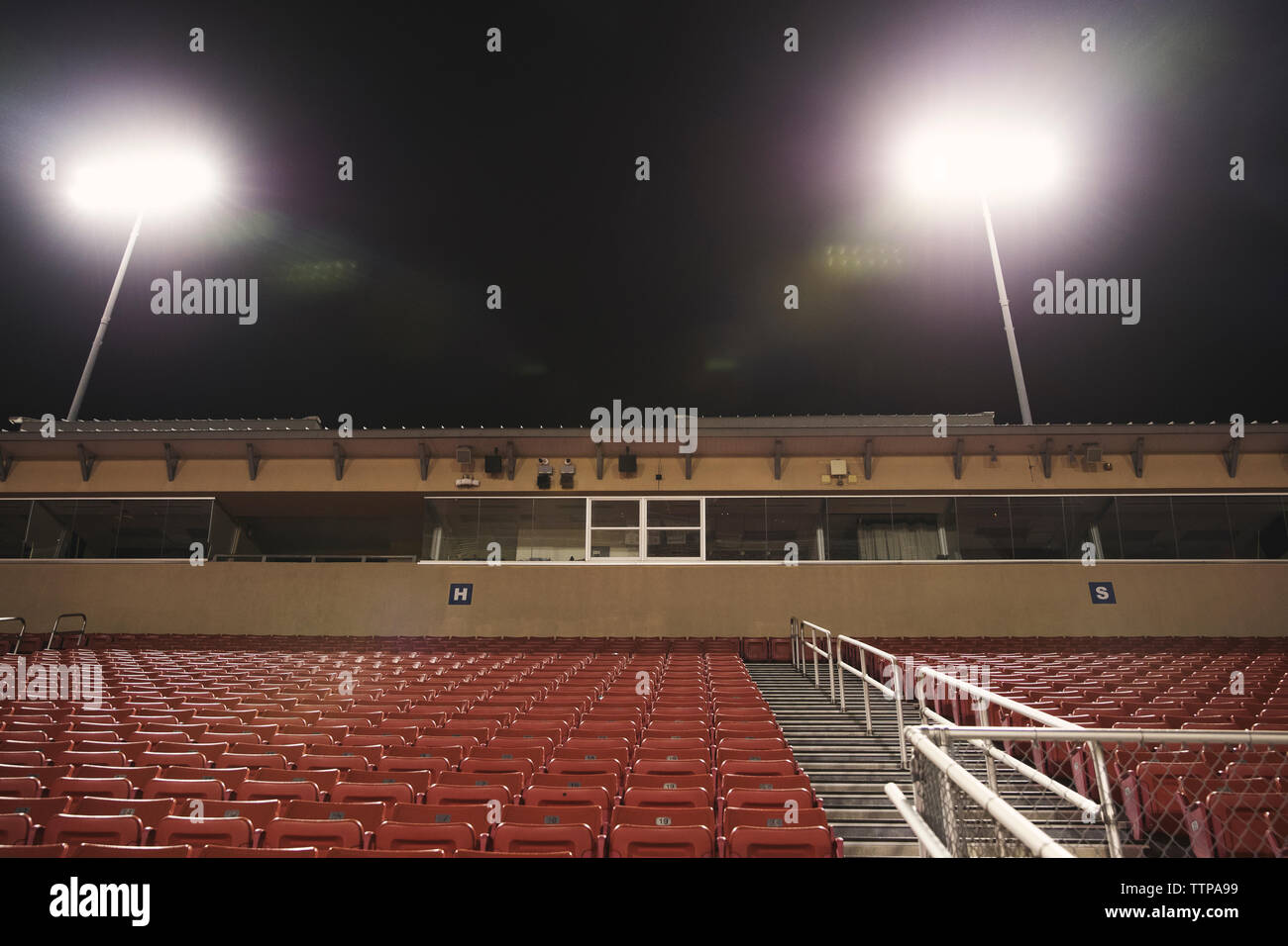 Low angle view of empty seats at illuminated American football stadium ...