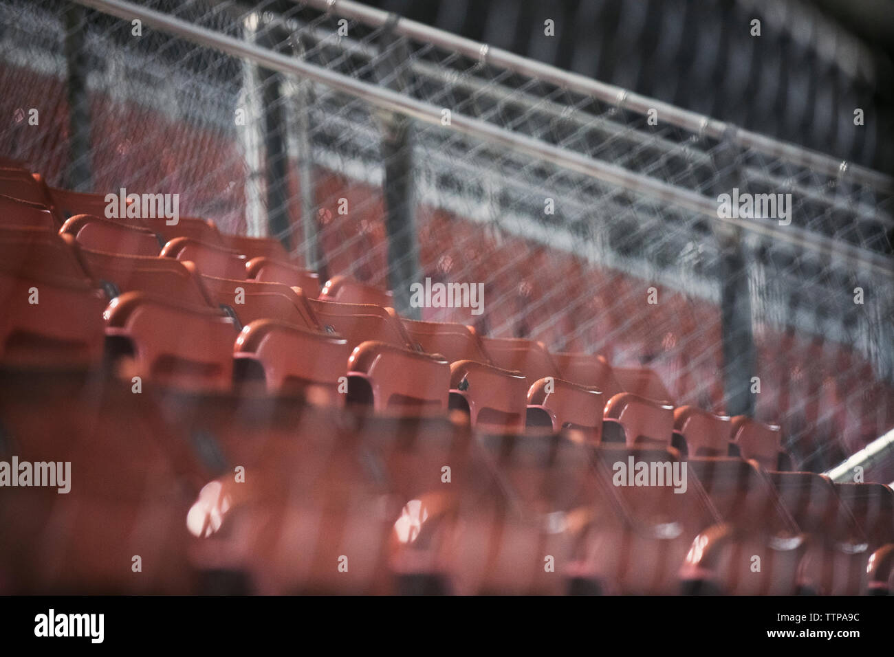 Low angle view of empty seats at American football stadium seen through ...