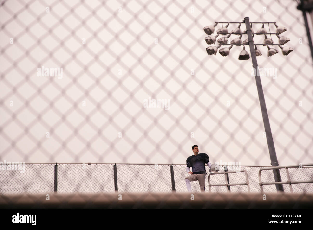 Low angle view of American football player looking away while standing ...