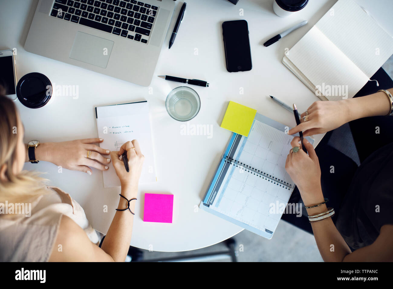 Overhead view of businesswomen planning at table in creative office ...