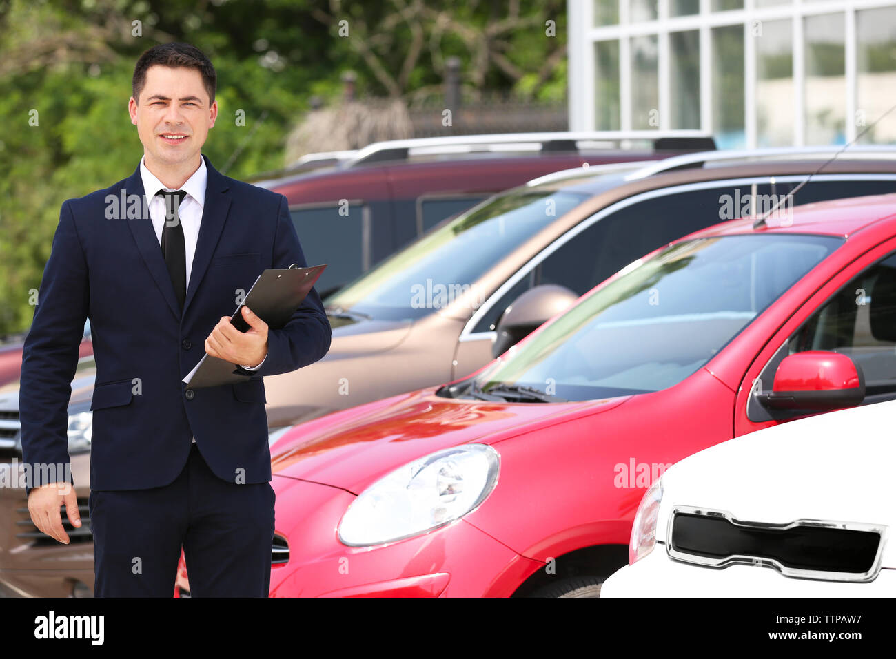 Car dealer on new cars background Stock Photo - Alamy