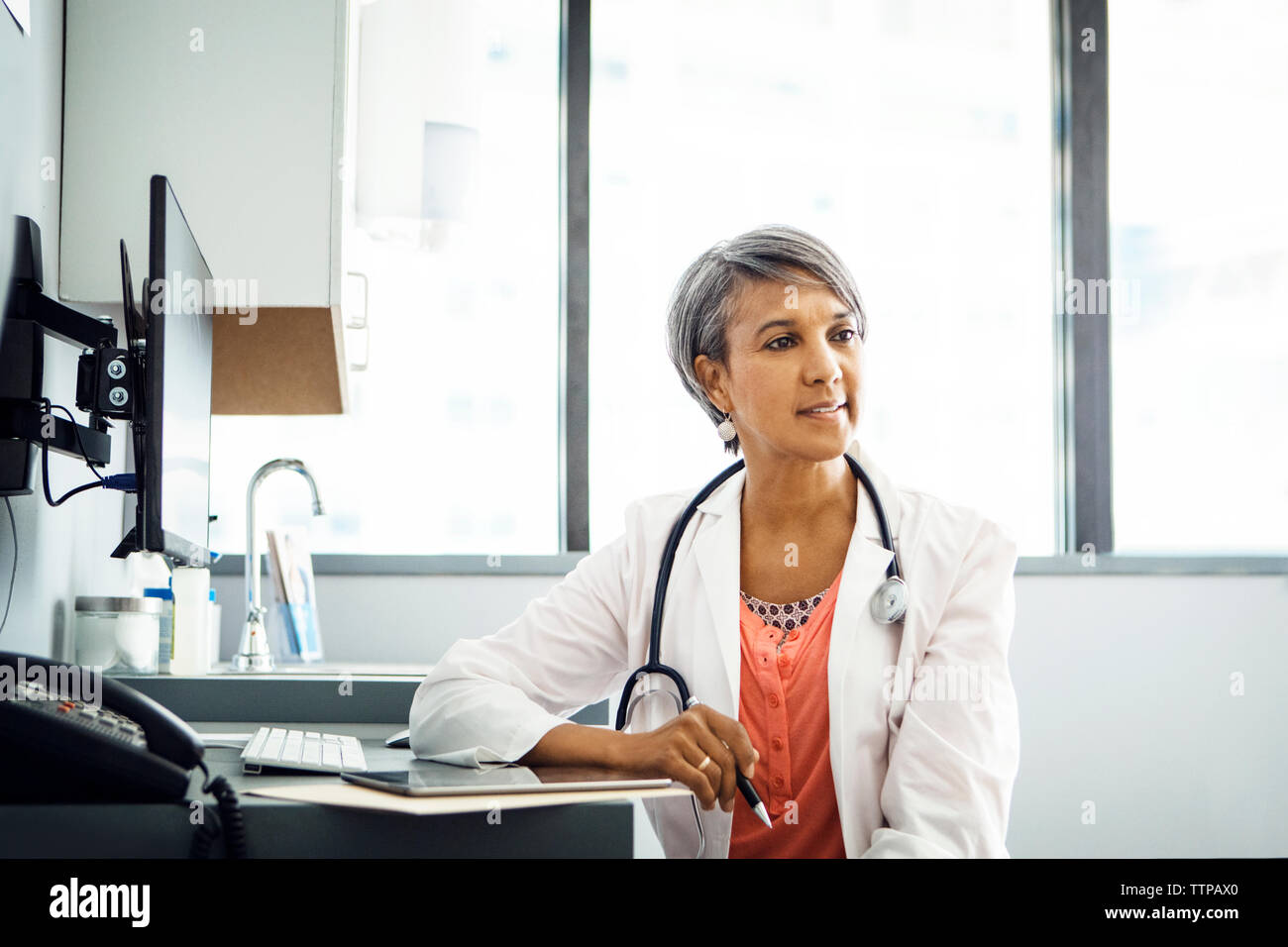 Doctor sitting at desk hi-res stock photography and images - Alamy