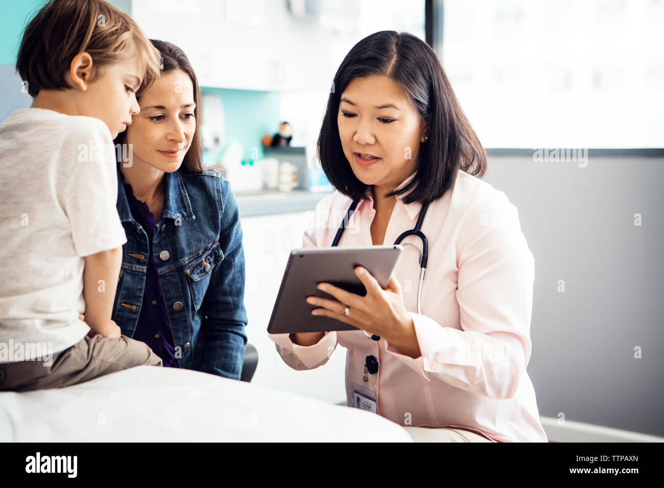 Female doctor examining boy mother hi-res stock photography and images ...