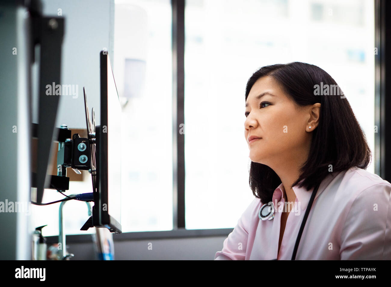 Female doctor using desktop computer in clinic Stock Photo - Alamy