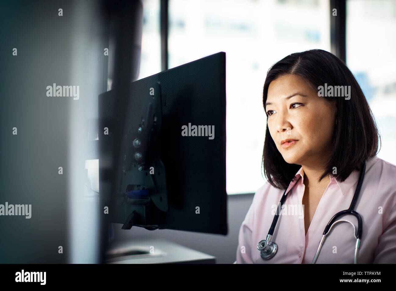 Female doctor using desktop computer in clinic Stock Photo - Alamy