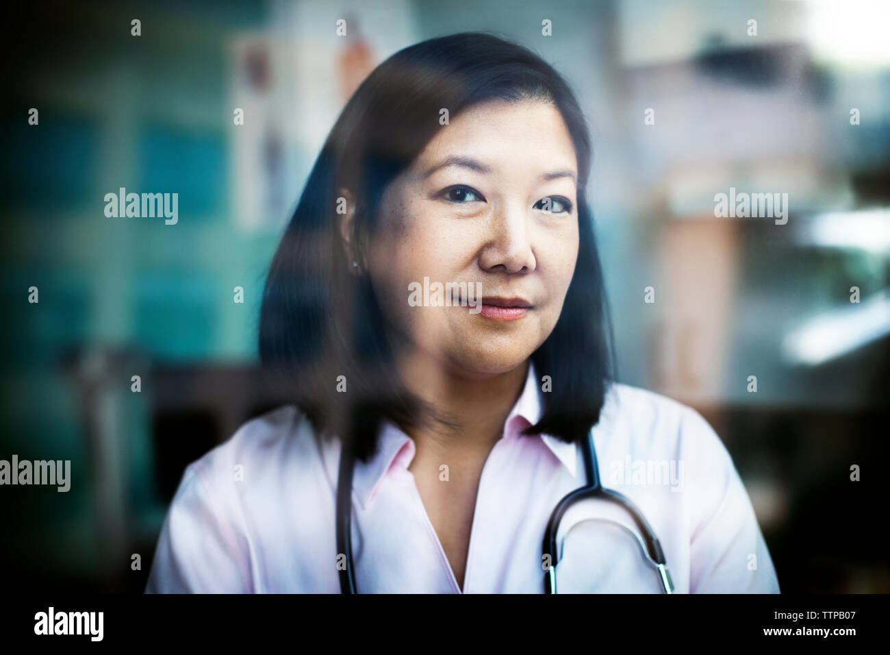 Portrait of confident female doctor seen through window Stock Photo - Alamy