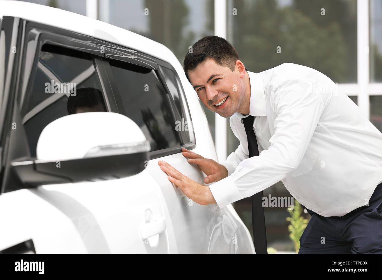 Man examining new car outdoors Stock Photo - Alamy