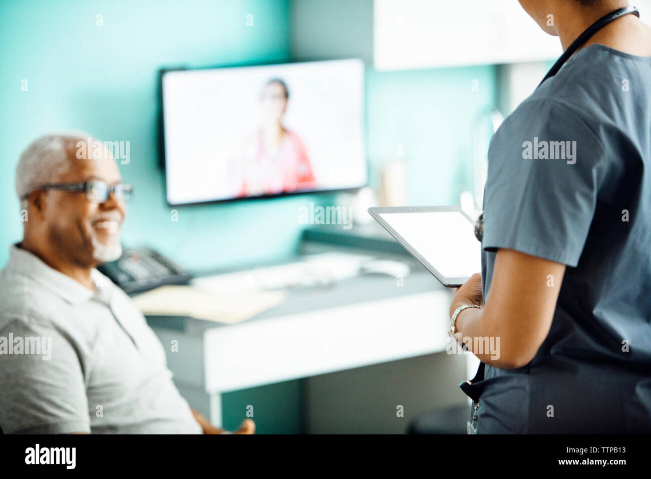 Midsection of female doctor with patient in clinic Stock Photo - Alamy