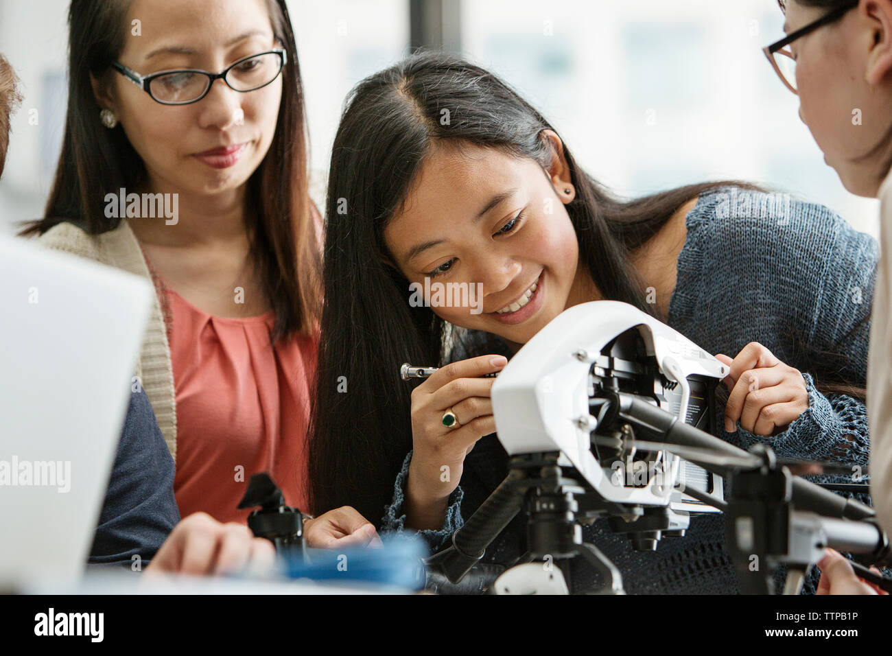 Teacher and students examining drone in classroom Stock Photo - Alamy