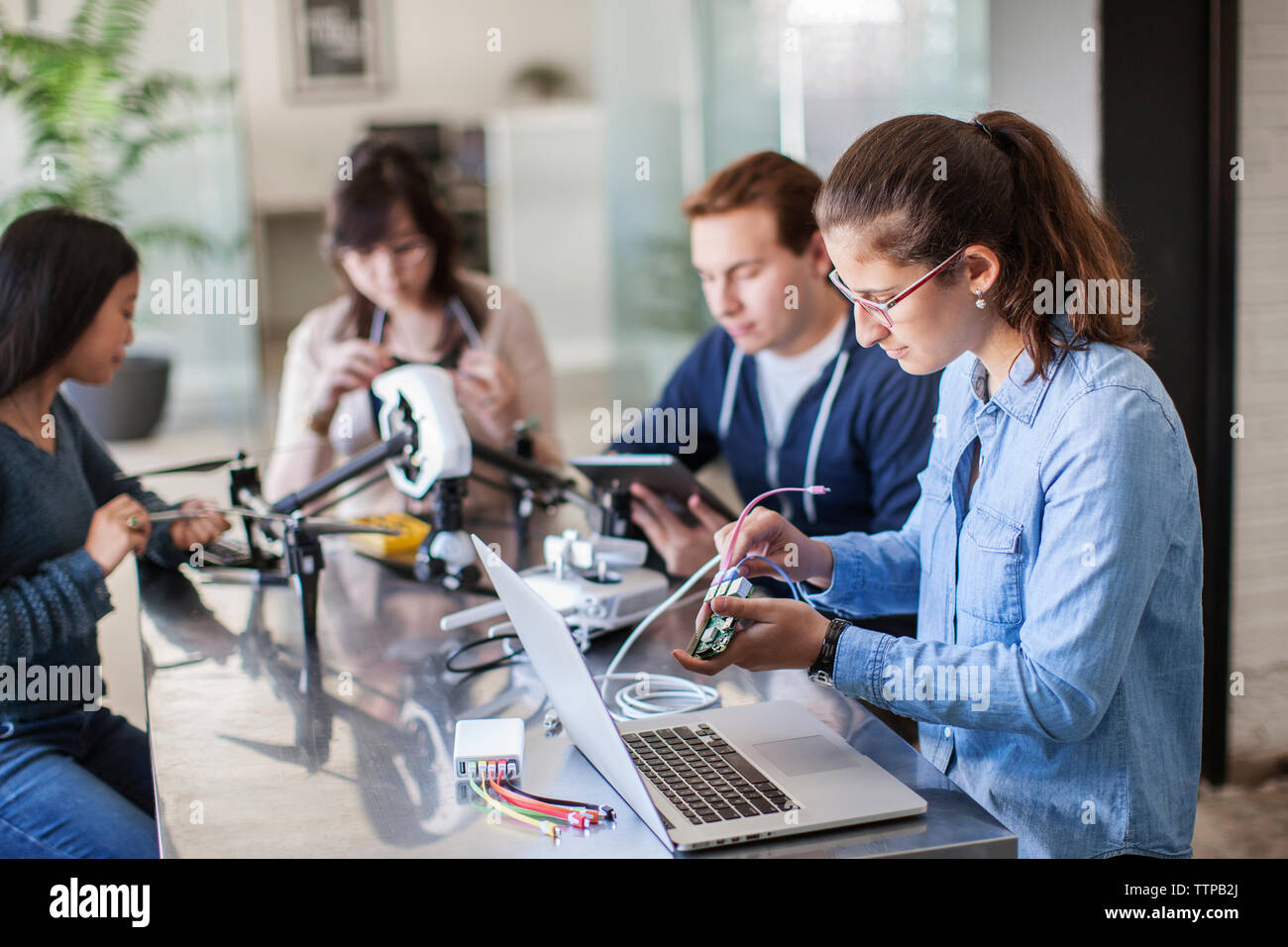 Students working with electrical equipment at table in classroom Stock ...