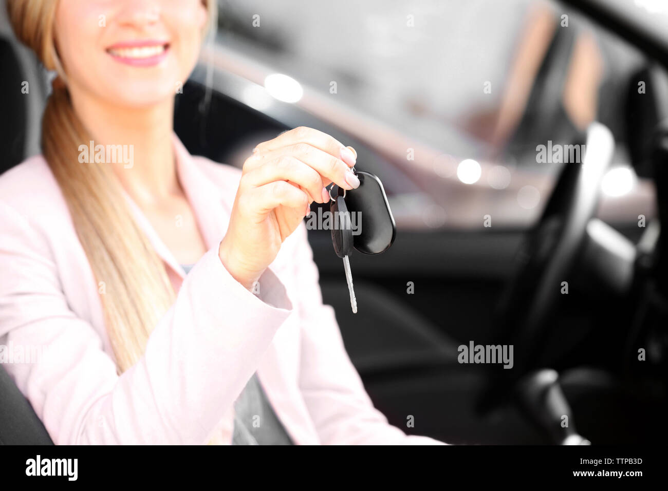 Woman holding key inside car Stock Photo - Alamy