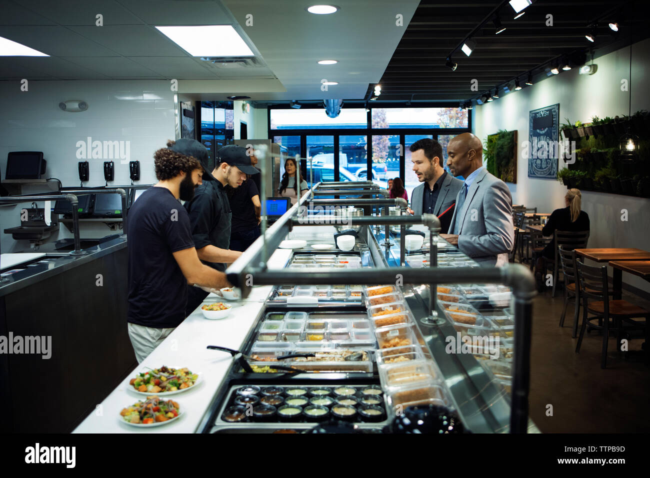 Happy business people ordering food in restaurant Stock Photo - Alamy