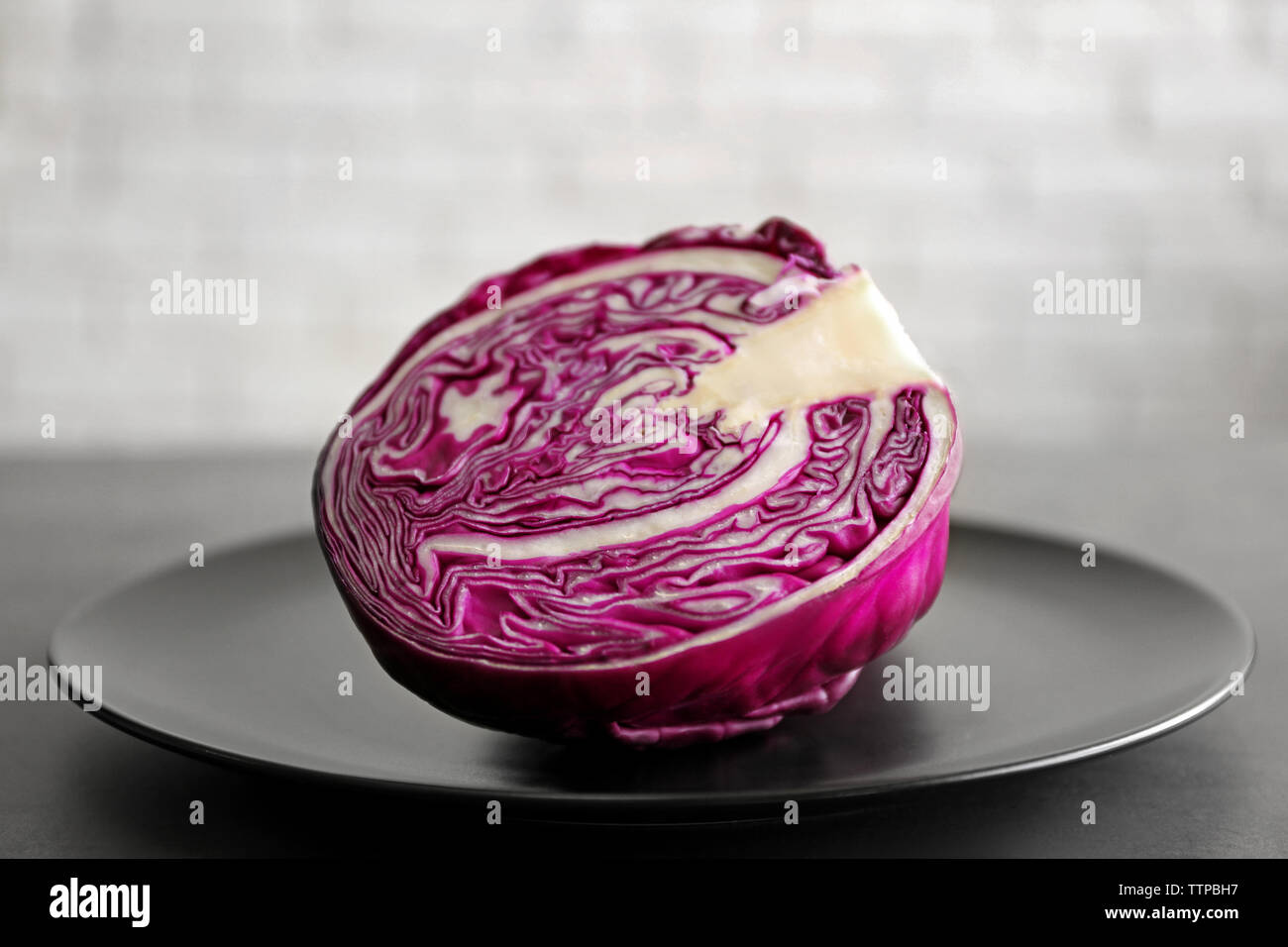 Red cabbage on plate, brick wall background Stock Photo - Alamy