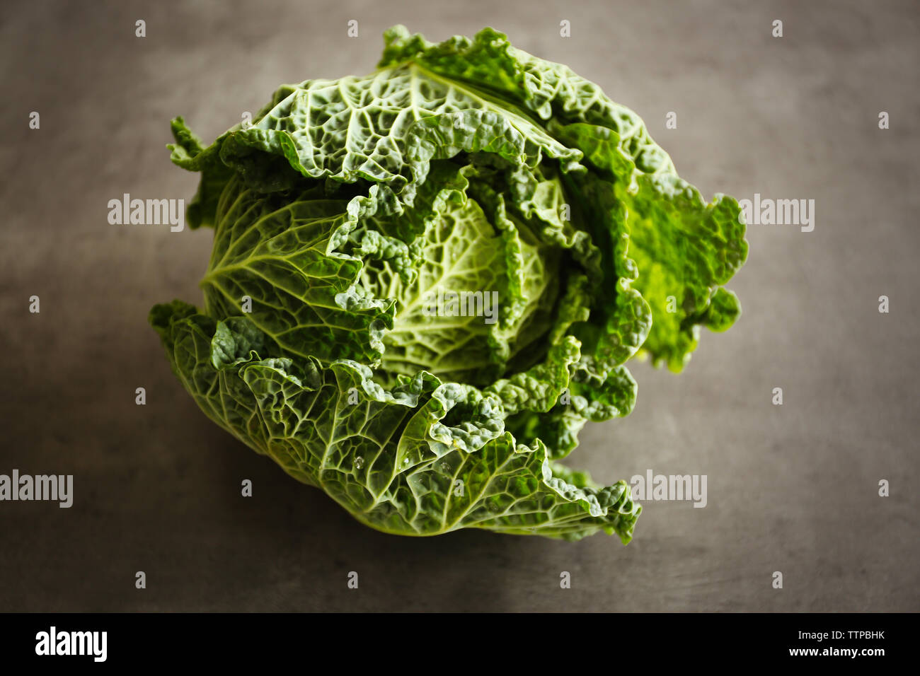 Fresh savoy cabbage on grey background Stock Photo - Alamy